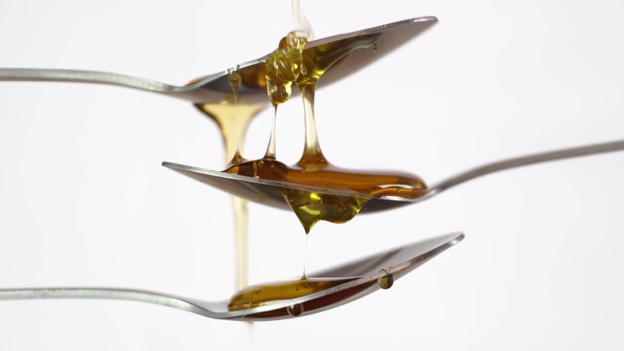 Premium stock video - Mesmerizing view of golden honey dripping down ...