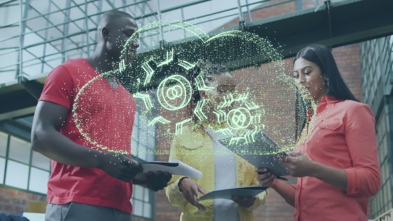 Animation of cloud with cog wheels over diverse colleagues discussing ...