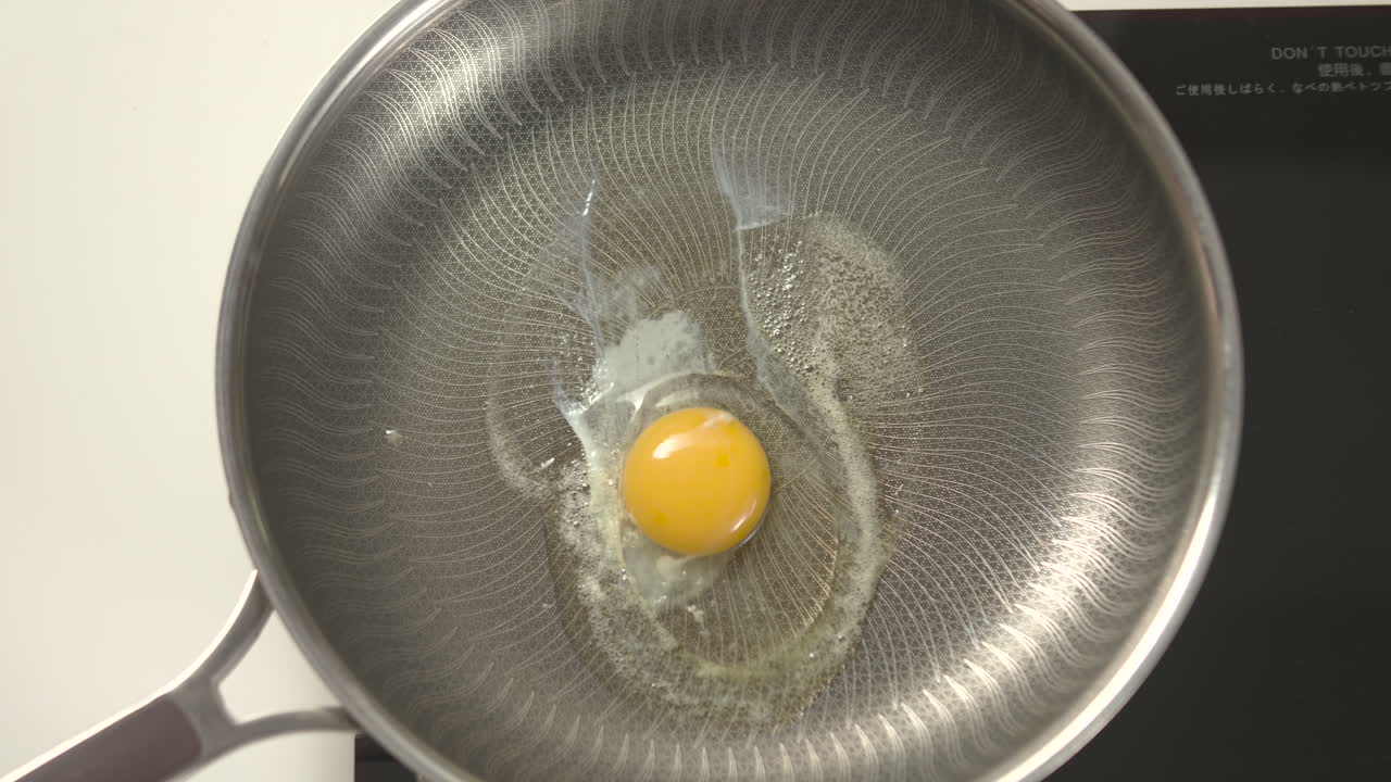 Premium stock video - Watch a perfect sunny-side-up egg sizzle with a ...