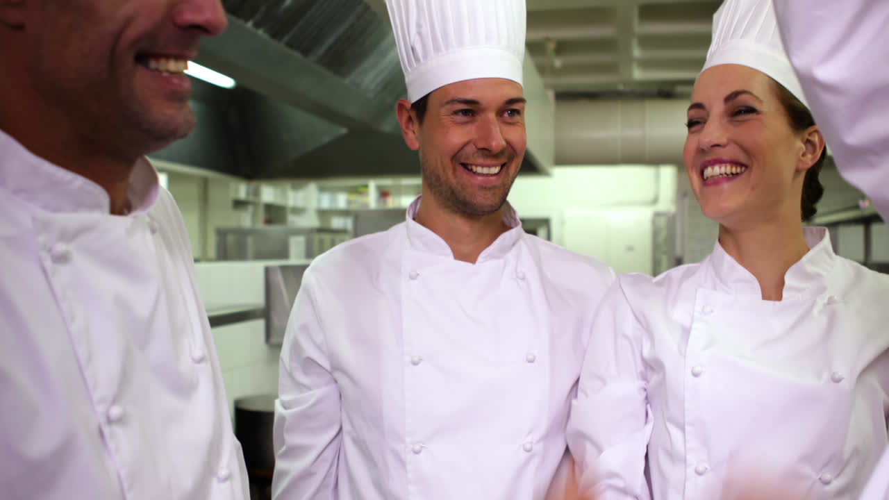 Premium stock video - Team of chefs putting hands together and cheering