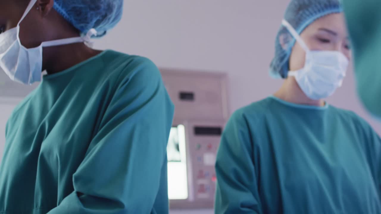 Video of diverse female surgeon and surgical assistants passing ...