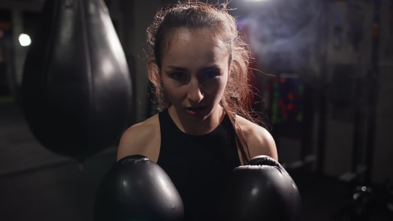Free stock video - Female boxer standing at dark gym, looking intensely ...