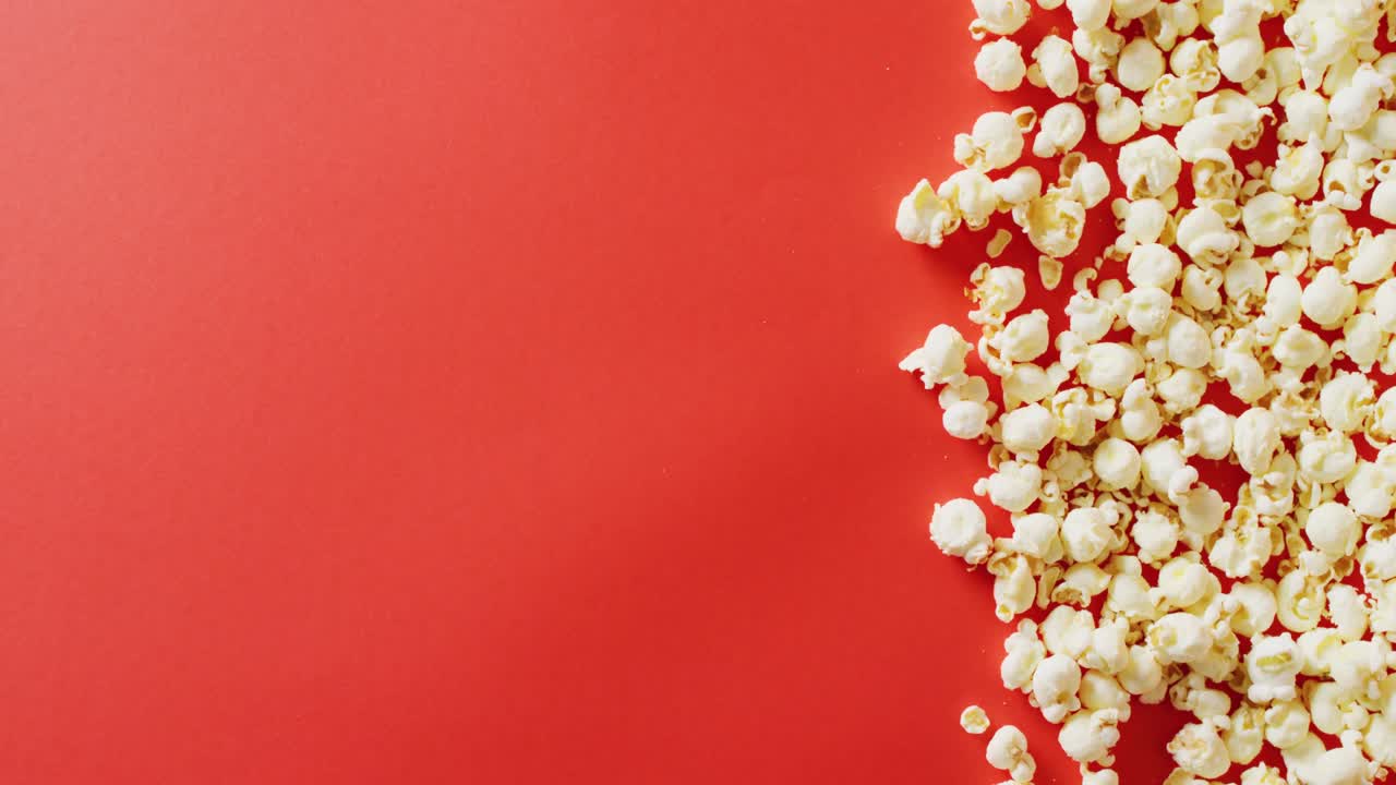 Premium stock video - Video of close up of popcorn on red background