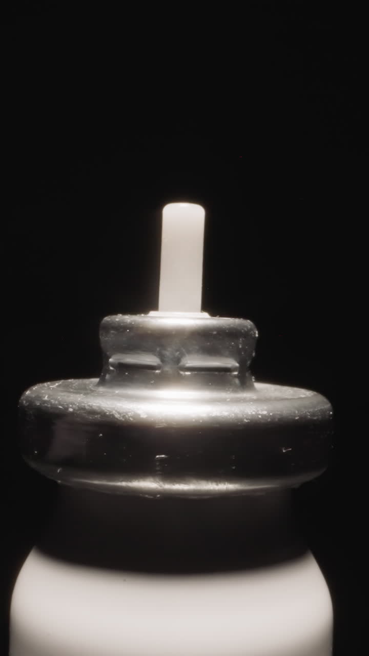 Bottle from inhaler with metal cap shining at bright studio light ...
