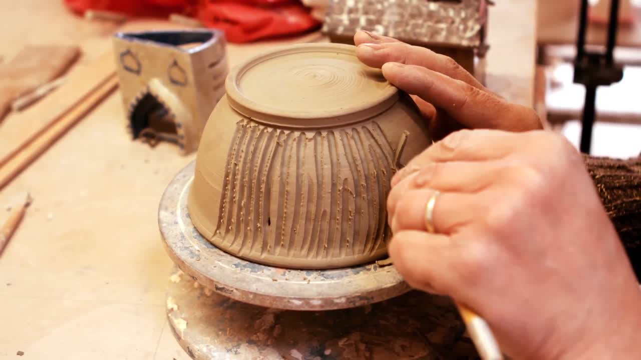 Premium stock video - Close-up of potter carving pot