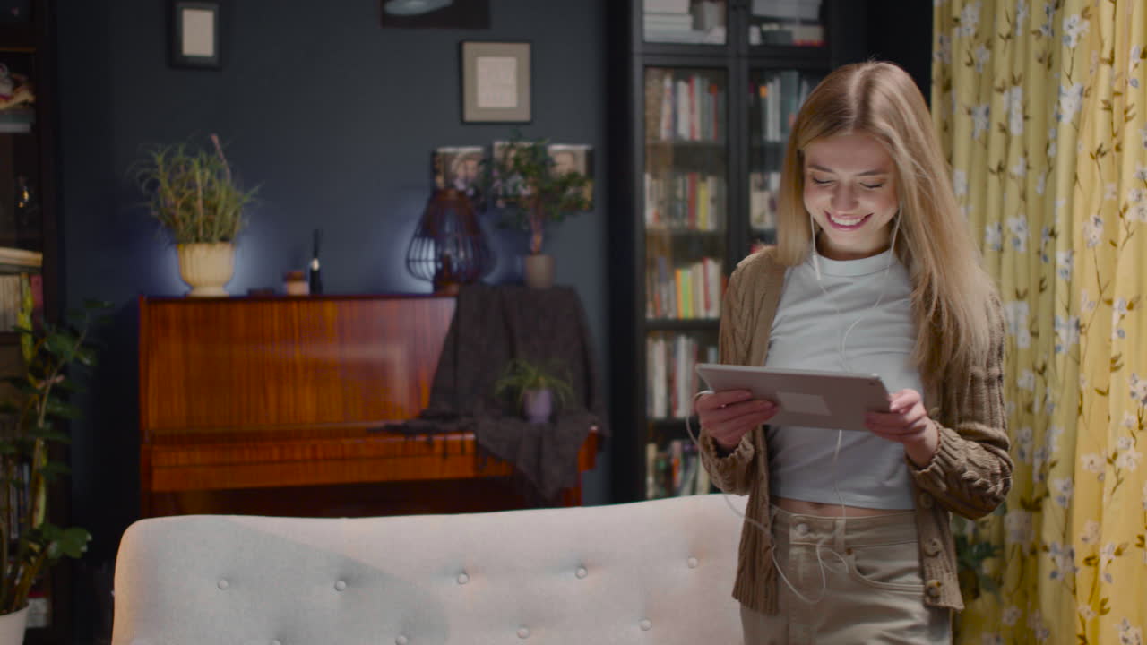 Free stock video - Happy young woman with earphones watching video on ...