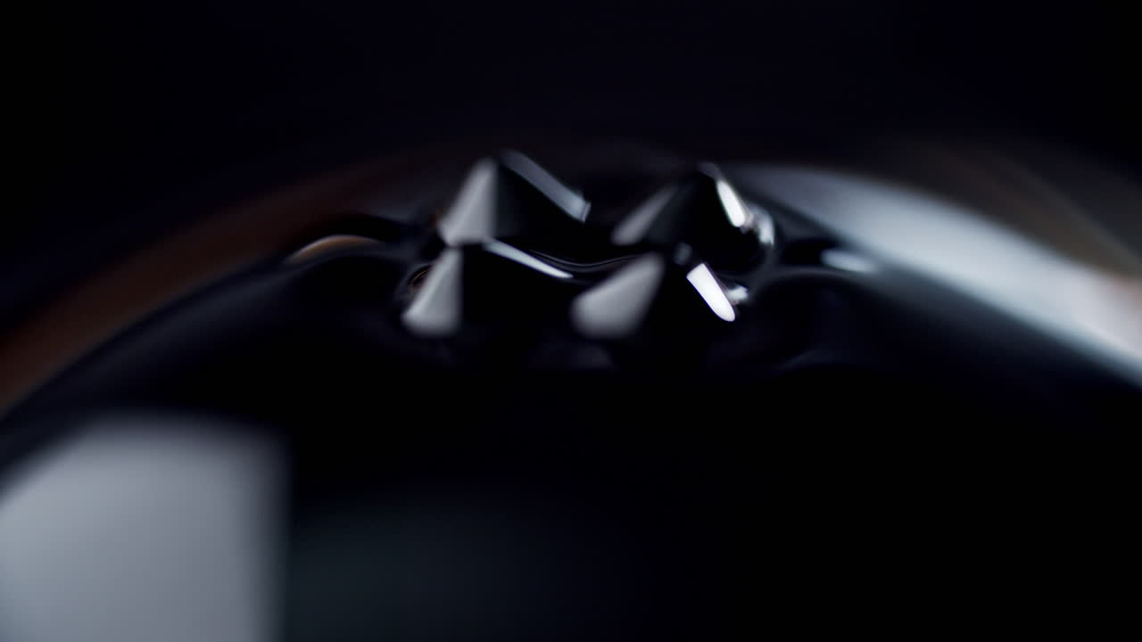 Premium stock video - Fluid forming spikes in a dark abstract atmosphere
