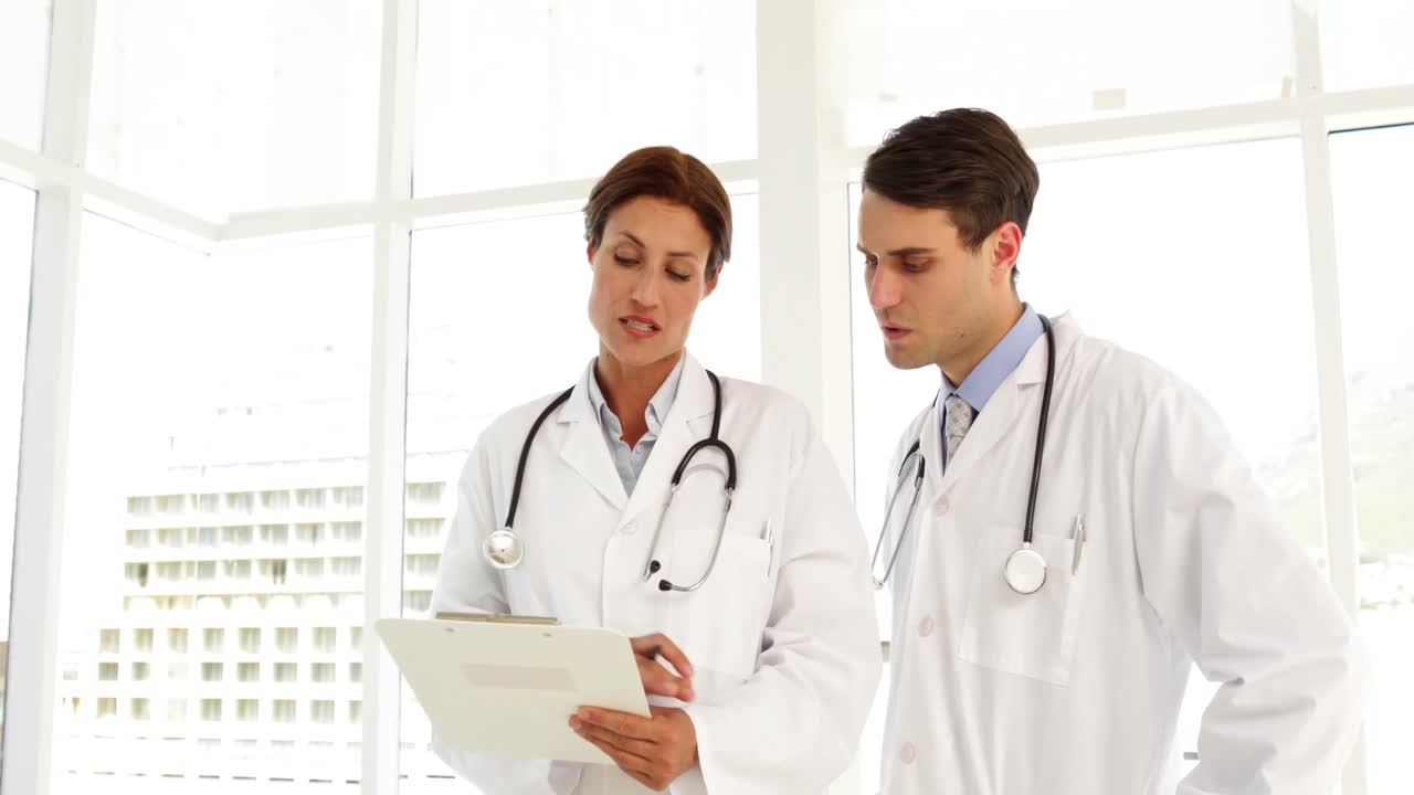 Premium stock video - Two doctors speaking about a file