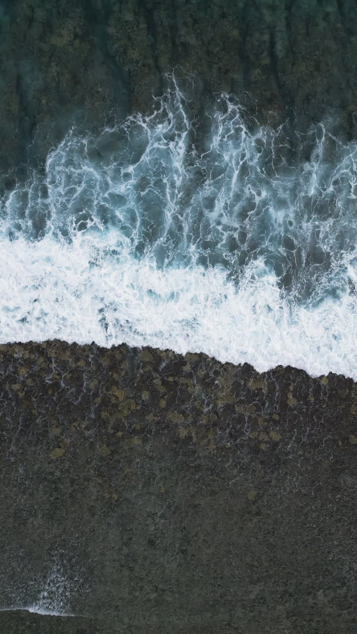 Drone descends on whitewash waves breaking on shallow fringing reef in ...