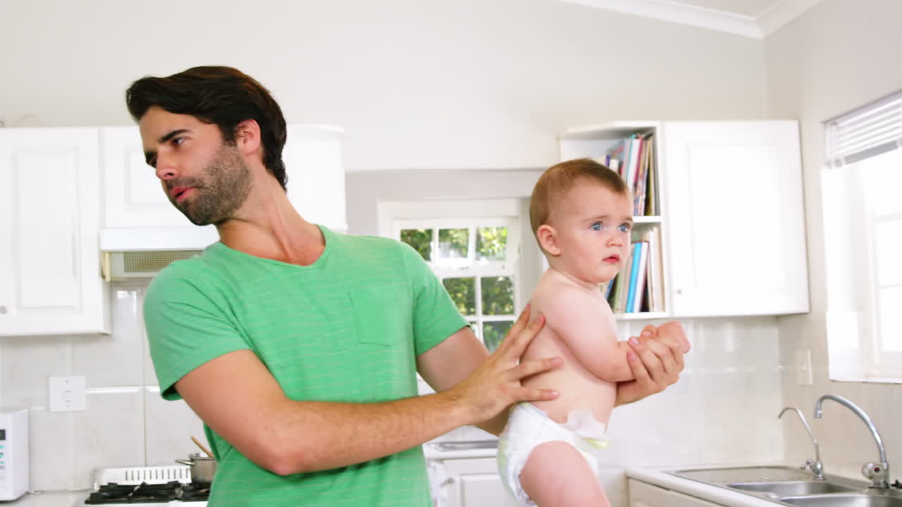 Premium stock video - Father checking diaper of son