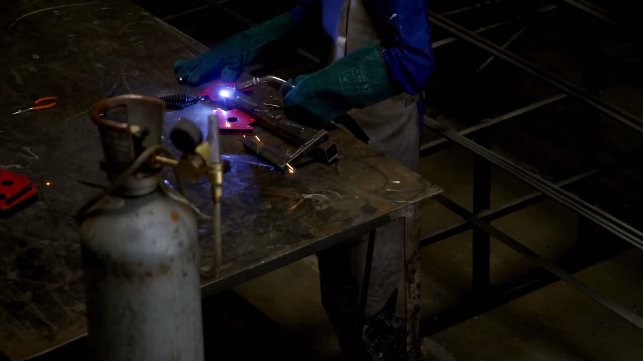 Female welder using blowing torch on a rod 4k | Premium Stock Video Footage