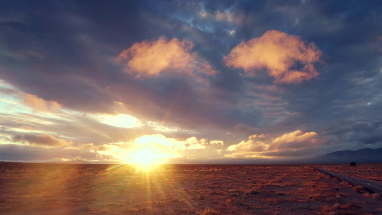 Bright golden sun with streaks rising over purple desert plain ...