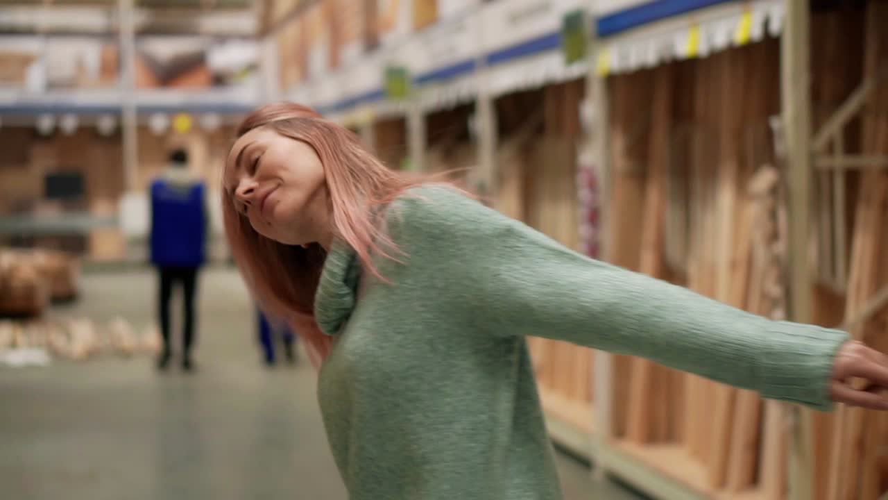 Free stock video - Young girl dances in hardware store relaxfully