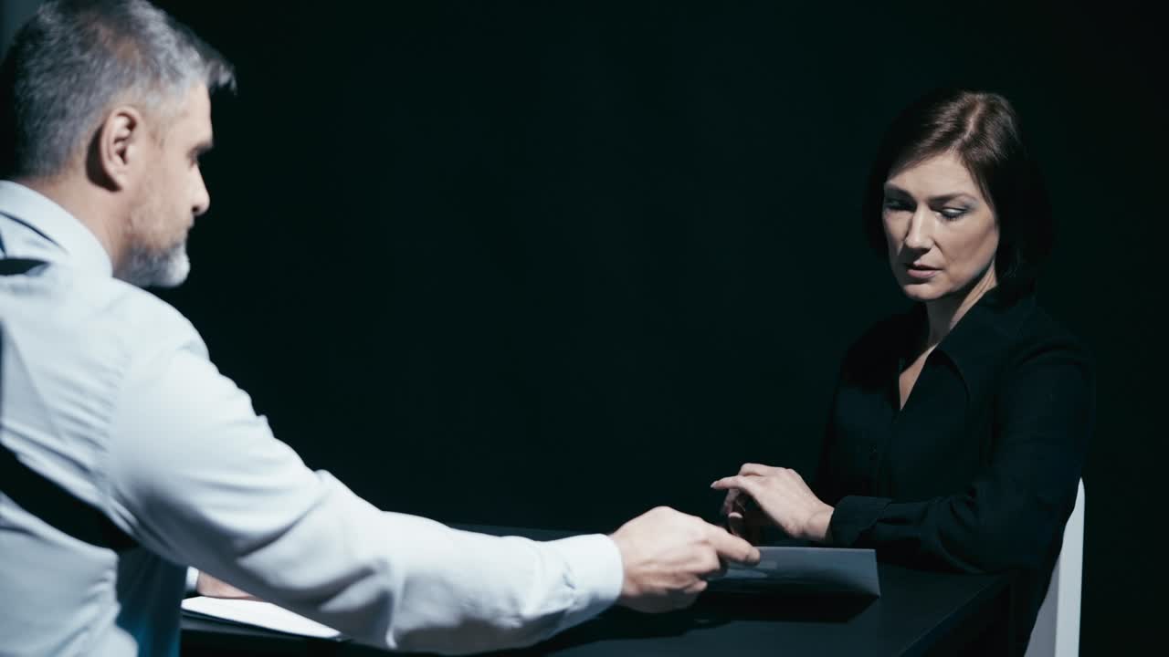Police detective showing evidence to female crime suspect ...