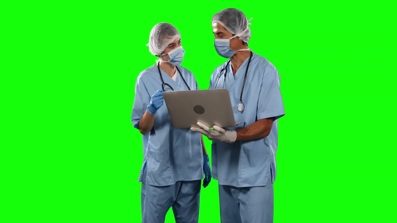 Front view of doctors watching some results on laptop with green screen ...