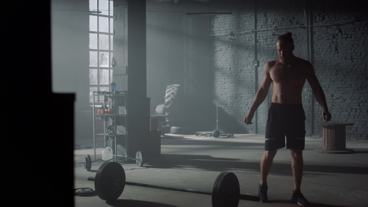 Premium stock video - Sportsman walking in club with barbell on floor ...