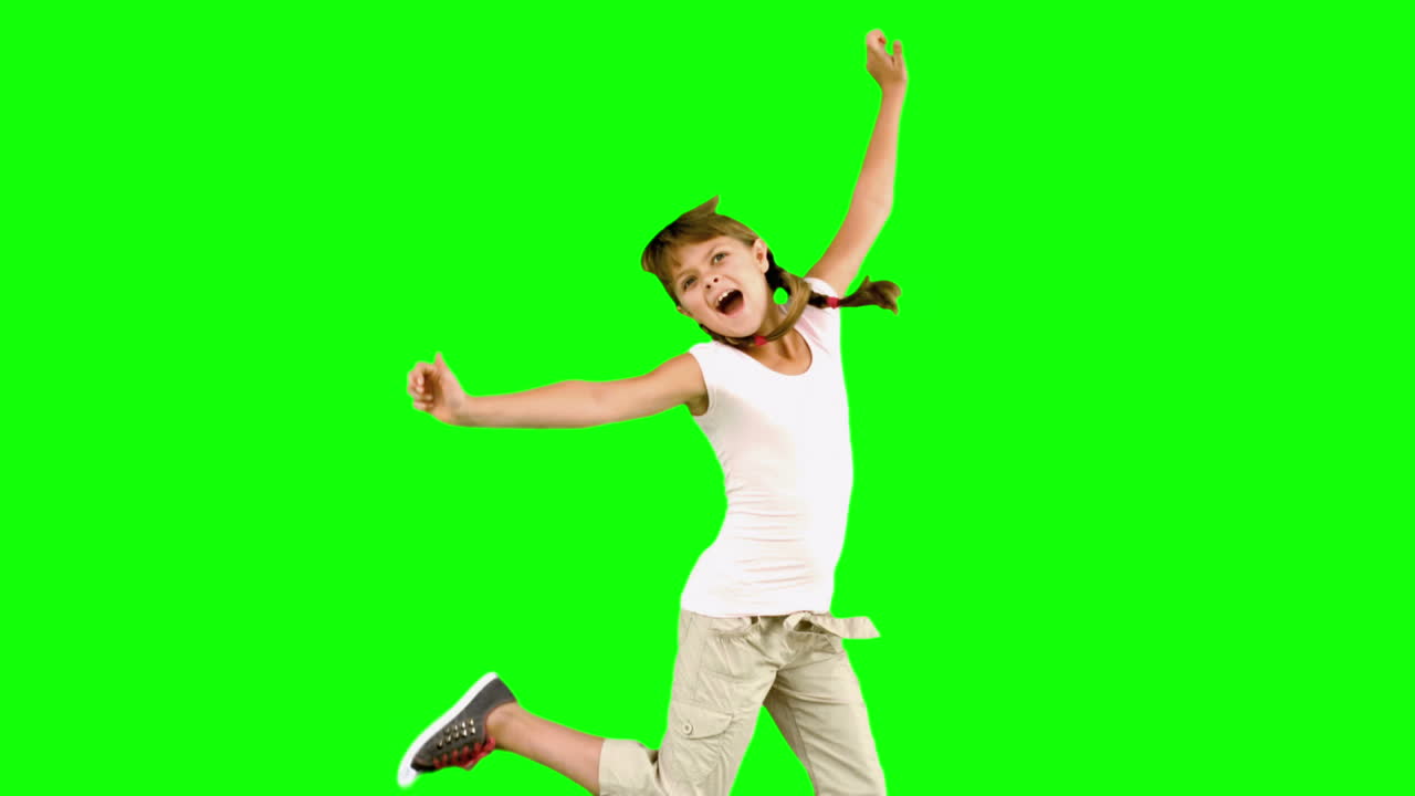 Premium stock video - Little girl jumping on green screen