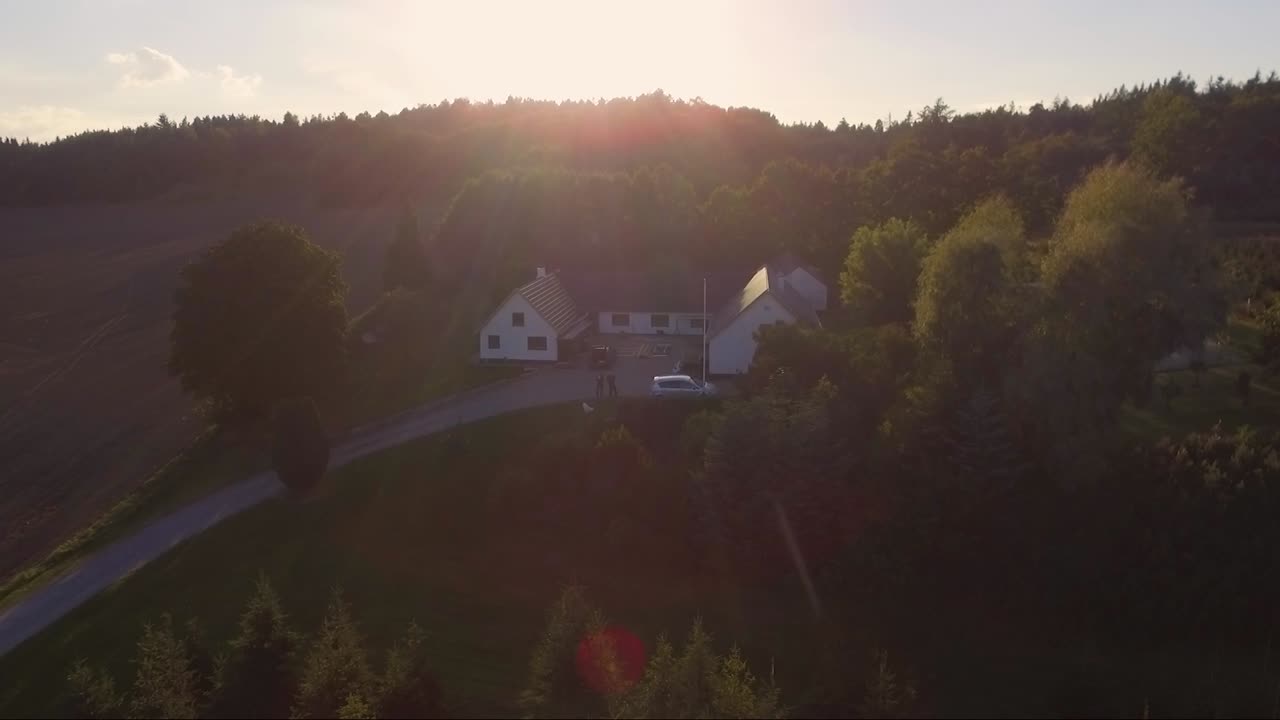 Aerial video approaching a farm during sunset at low height above the ...
