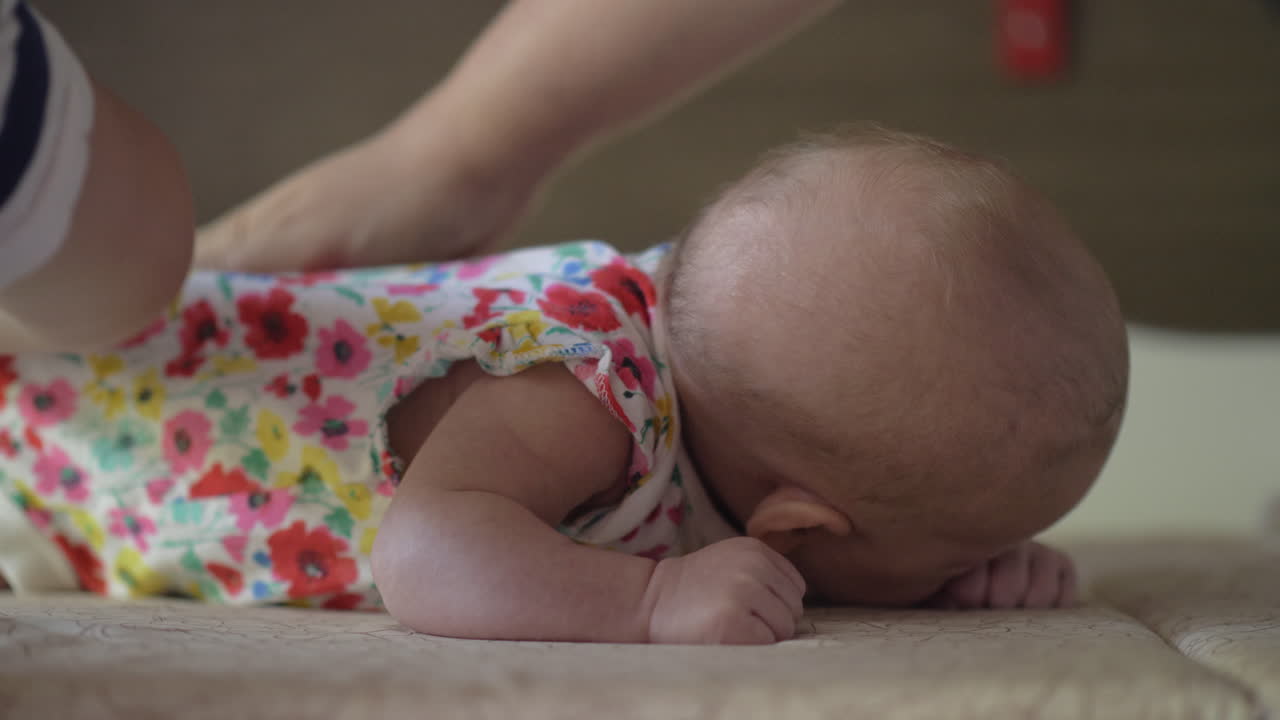 Premium stock video - Mother and elder child looking after baby at home
