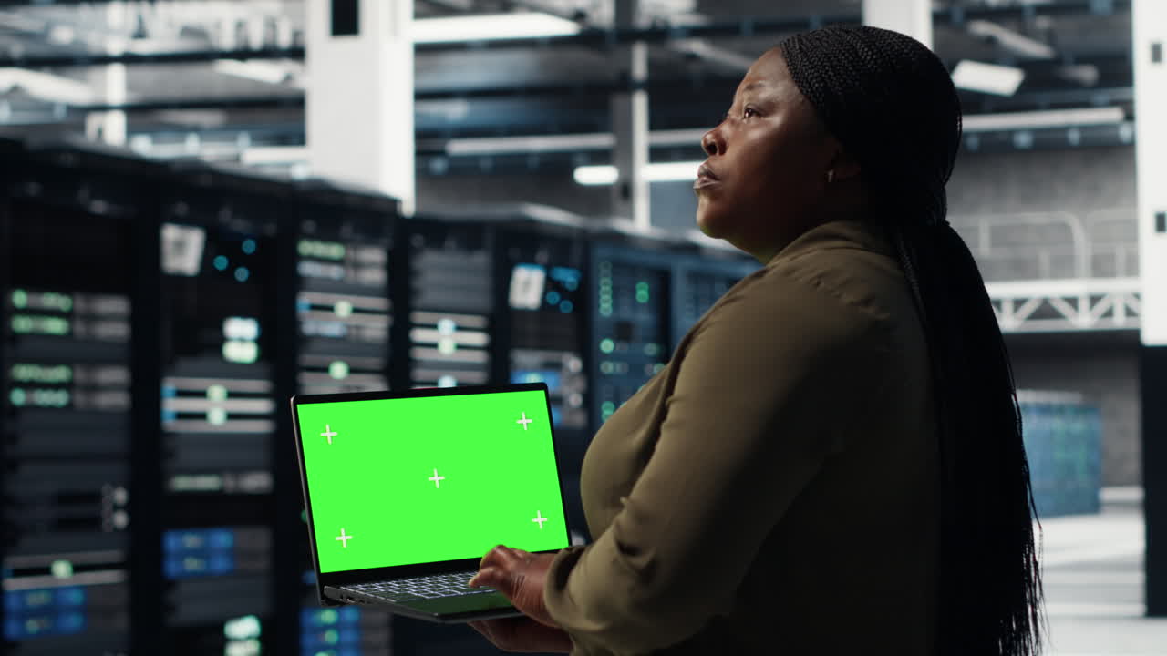 Server room admin uses green screen laptop to upgrade mainframes ...