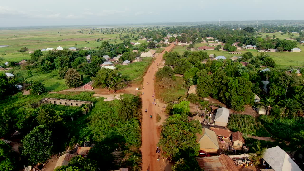 Motorcycle Traffic Along A Red Dirt Unpaved Road In Rural Rukubi ...