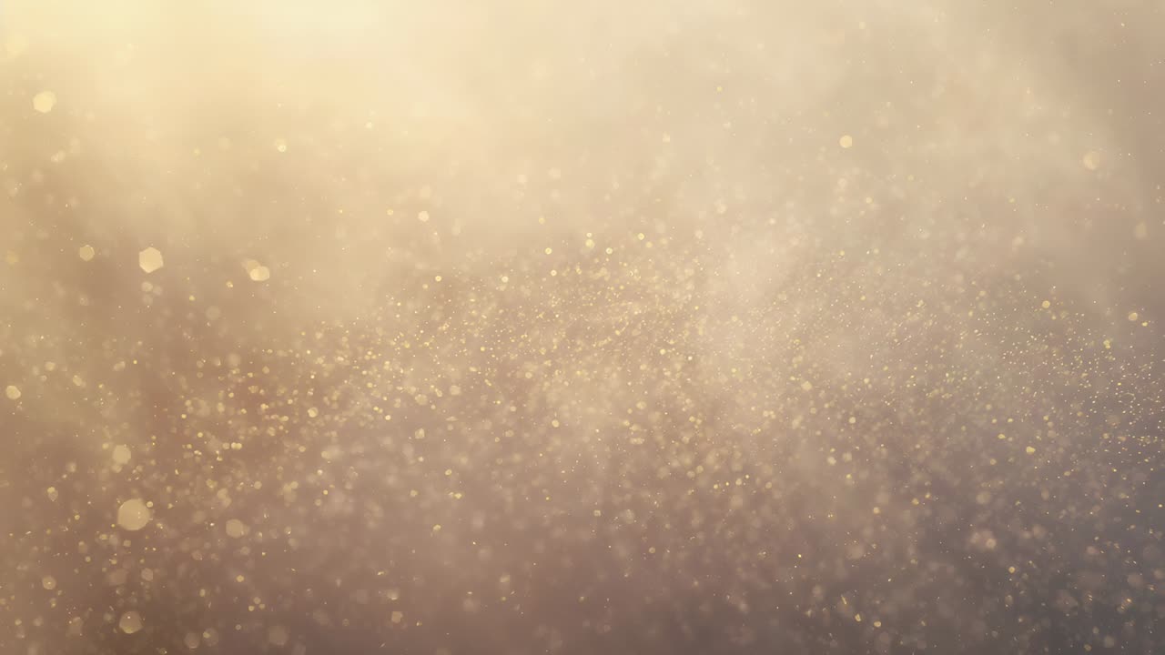 Soft airflow starting gold dust drifting, growing in closeup studio ...