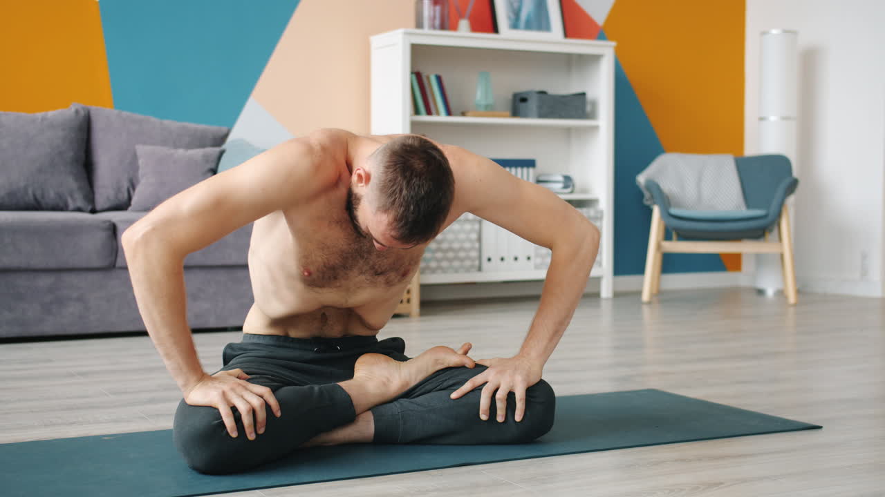 Man practicing seated backbend yoga pose at home | Premium Stock Video ...