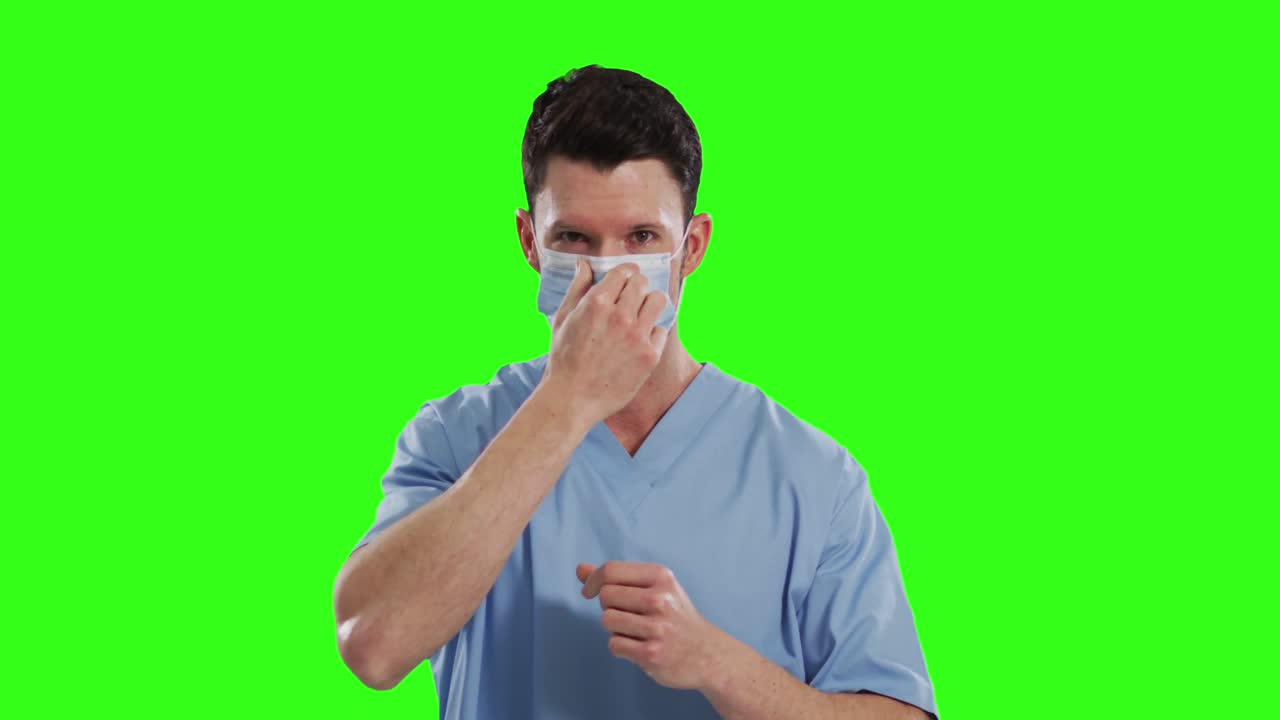 Premium stock video - Caucasian male doctor wearing face mask on green ...