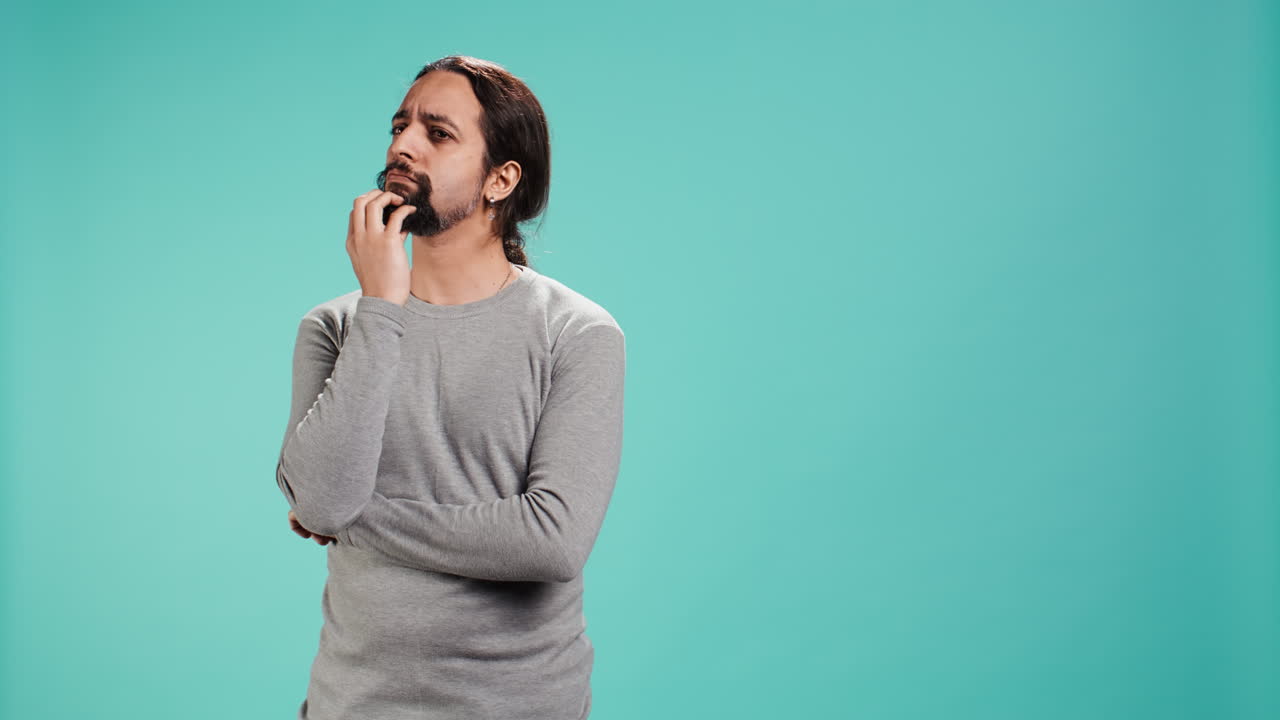 Premium stock video - Unsure person doing stroking chin gesture, thinking
