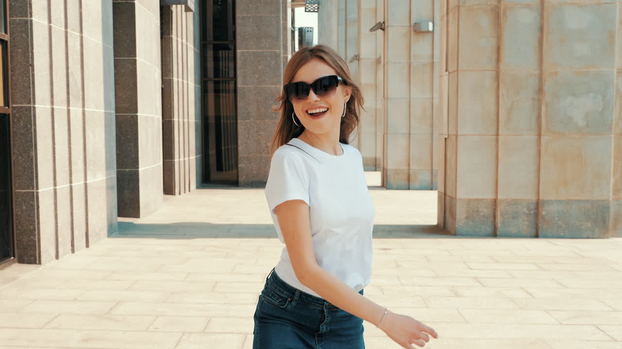 Mujer sonriente con gafas de sol y vaqueros | Vídeo de stock Premium