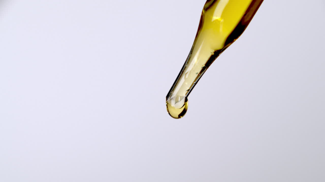 Yellow Liquid Drops Falling From Glass Pipette, Close Up View Isolated ...