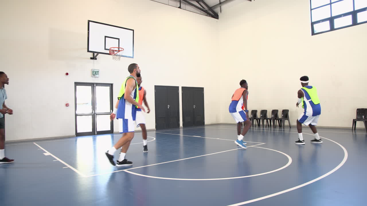 Multiracial male basketball players running, passing and throwing ...
