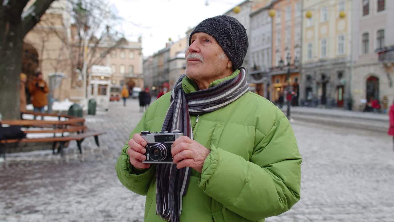 Senior old man taking pictures with photo camera, smiling using retro ...