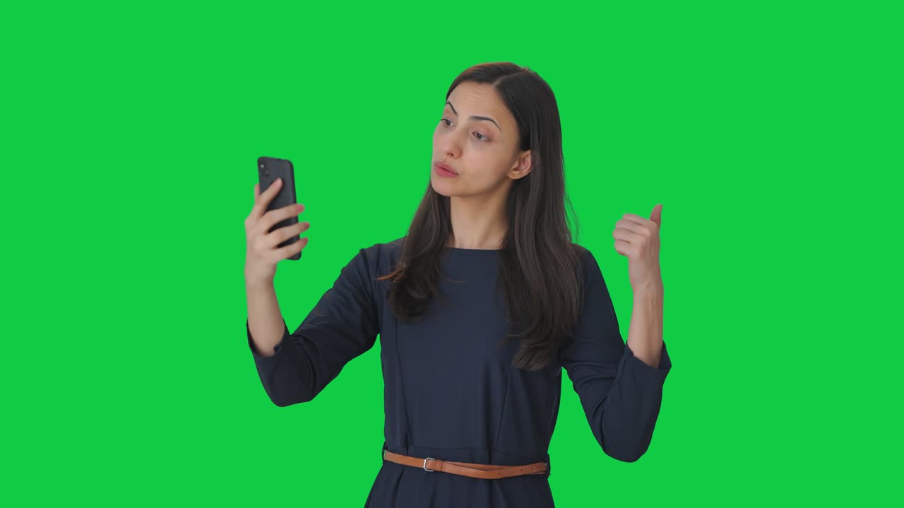 Premium stock video - Indian girl talking on video call green screen
