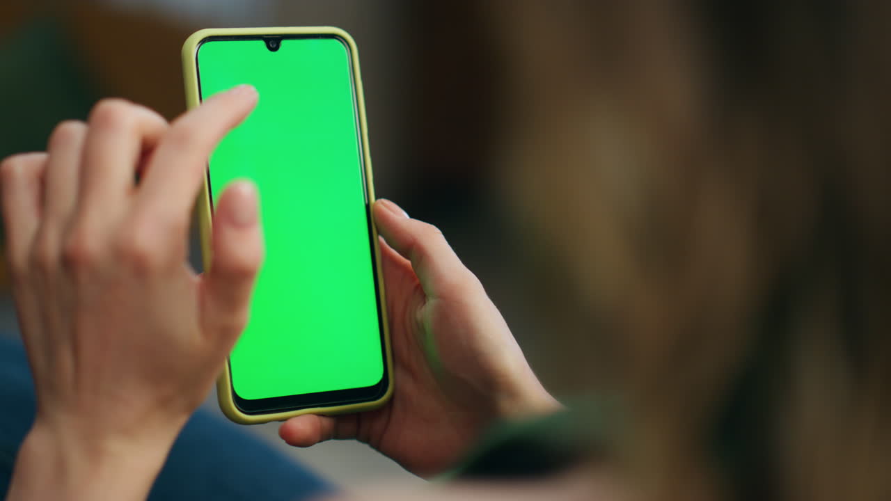 Premium stock video - Woman hand swiping green phone screen closeup. unknown relaxed girl scrolling