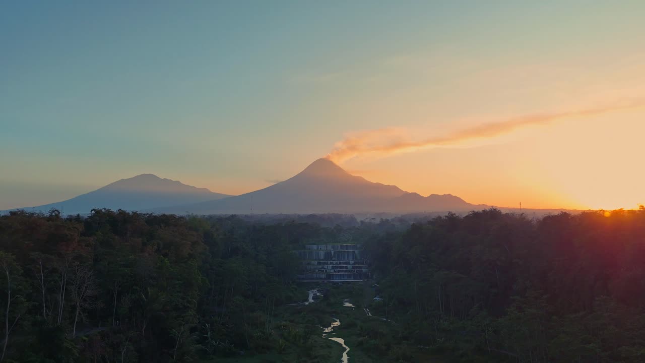 Majestic view of Merapi Volcano and Awatu Purbo Waterfall at sunrise in ...