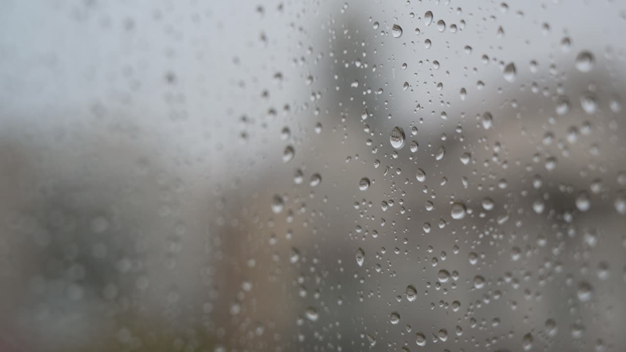 Premium stock video - Close-up view of raindrops on a window looking ...