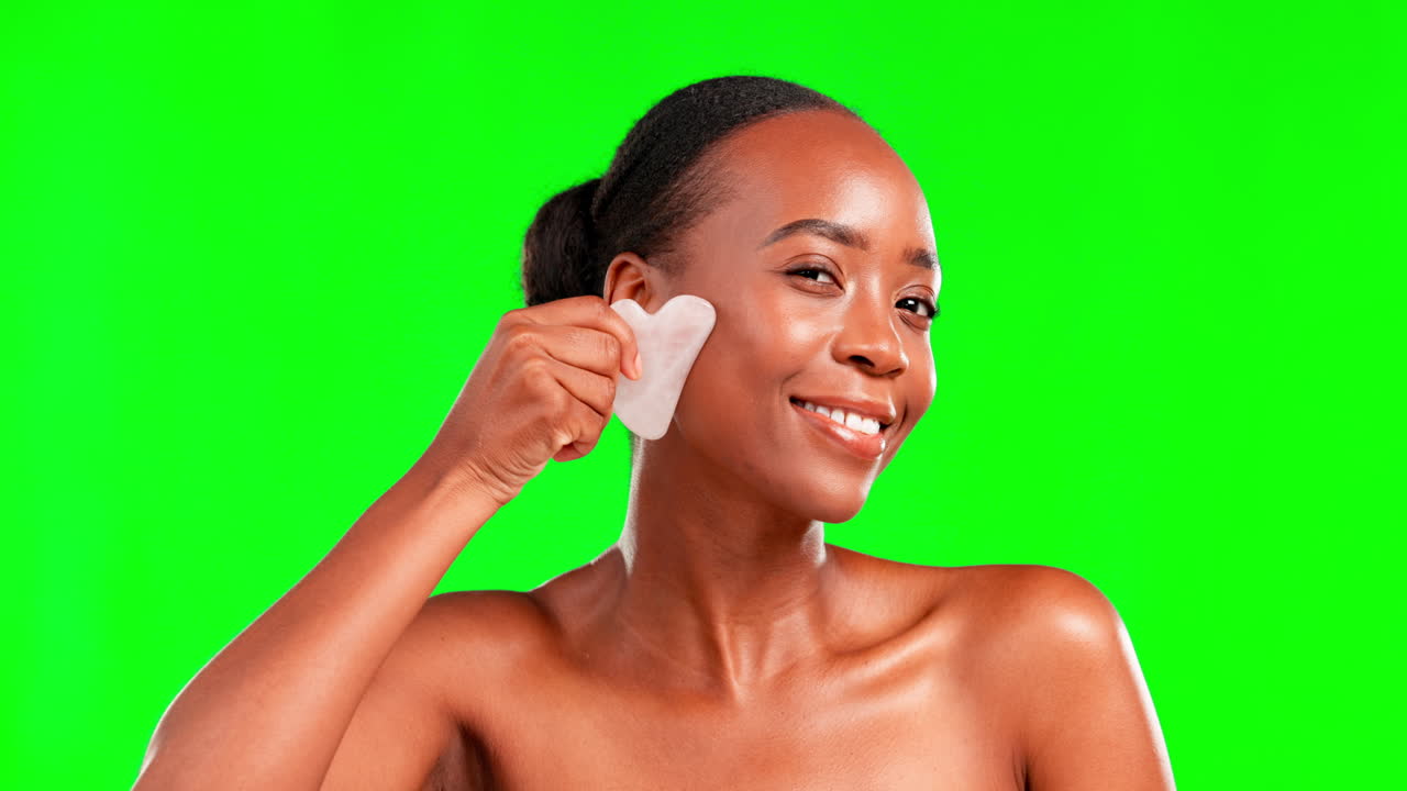 Premium stock video - Black woman, beauty and gua sha in studio