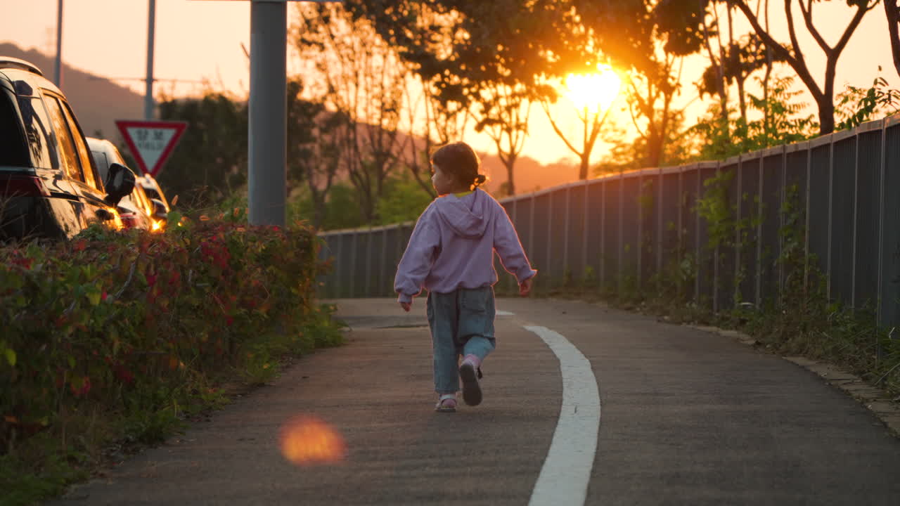 Premium stock video - Rear of a child on the sidewalks during sunset ...