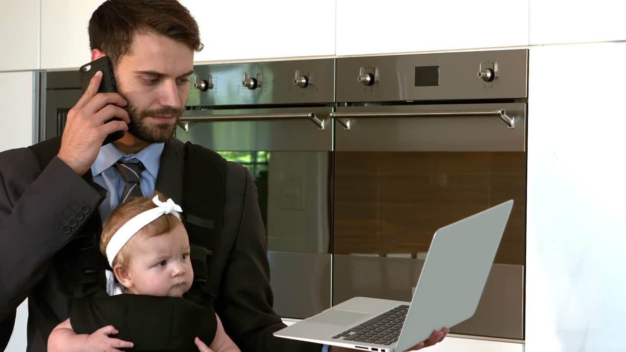 Premium stock video - Portrait of busy father multi tasking