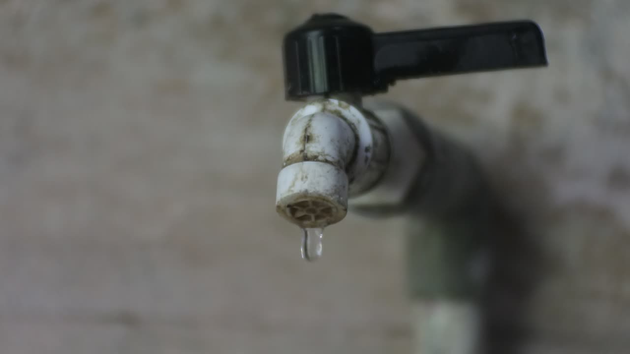 Water comes out of a bucket in a faucet, water flows on a small scale ...