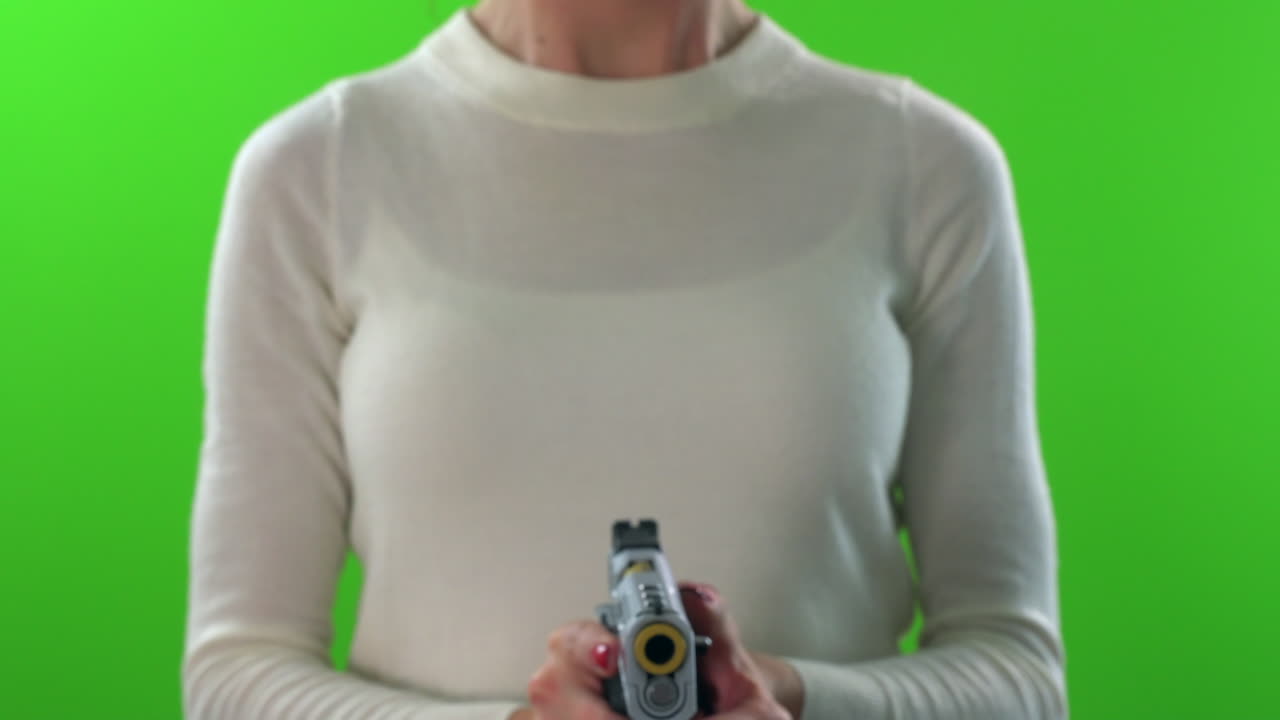 Premium stock video - Female pointing gun forward, cocking and firing ...