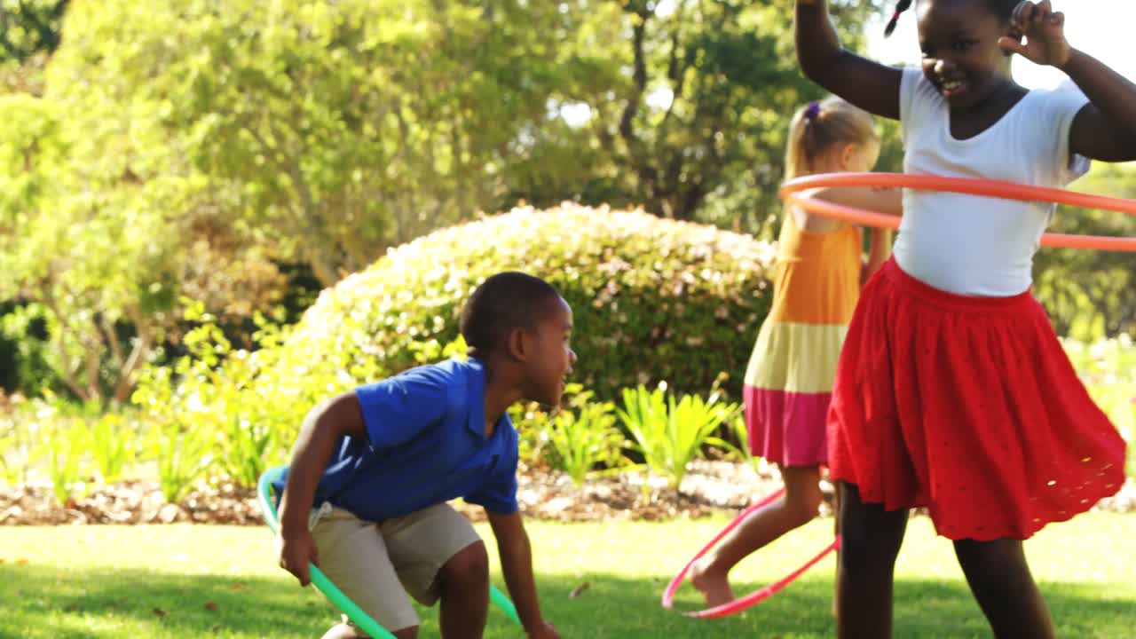 Premium stock video - Group of kids twirling hula hoop