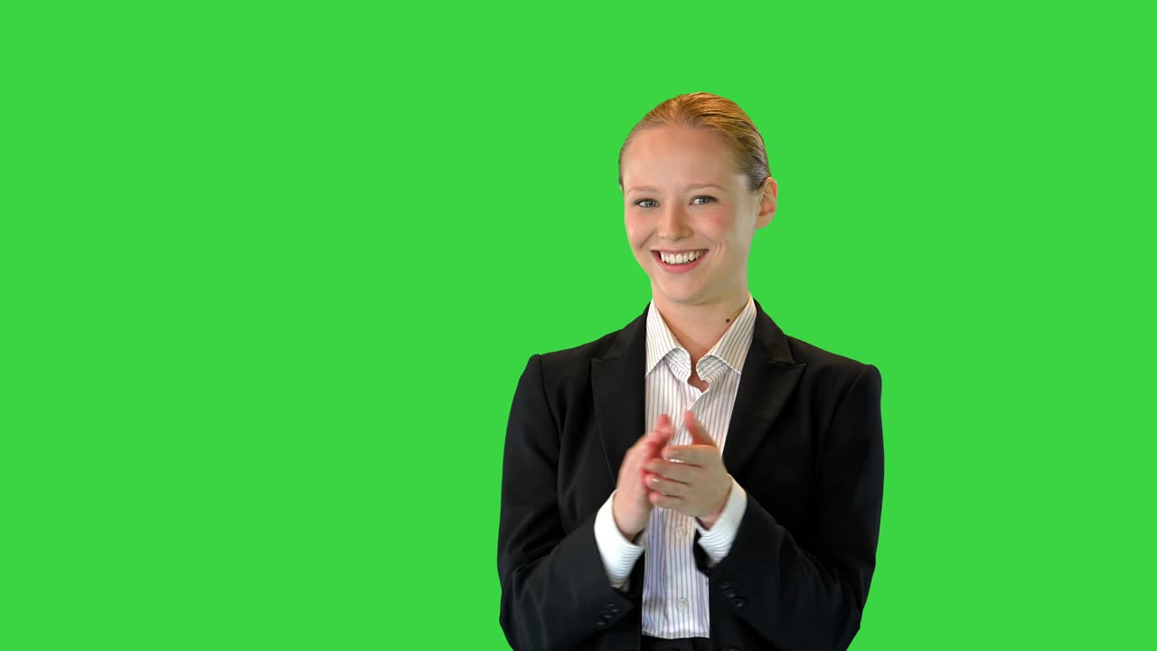 pretty blonde woman smiling and clapping hands on a green screen chroma ...