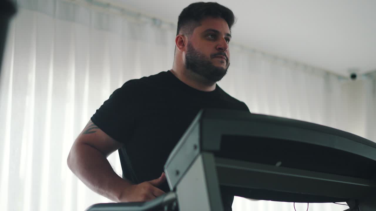 Man in slow motion training cardio exercise on running machine in gym ...