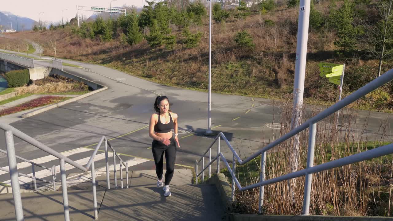 Athletic young woman striving for healthy lifestyle running up steps ...