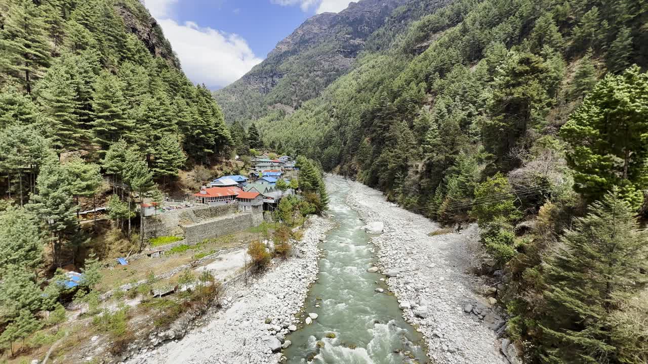 A pristine Himalayan river winds through vibrant green mountains ...