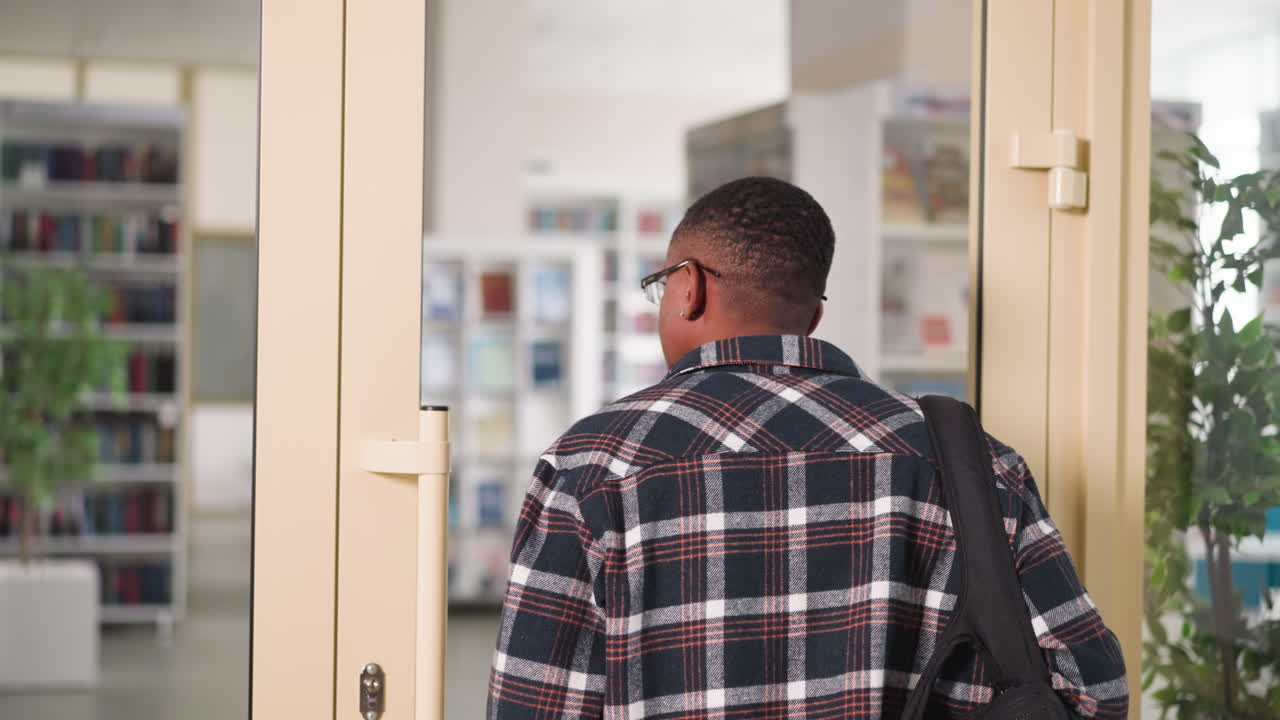 Doubting man looks through closed library door. african american ...