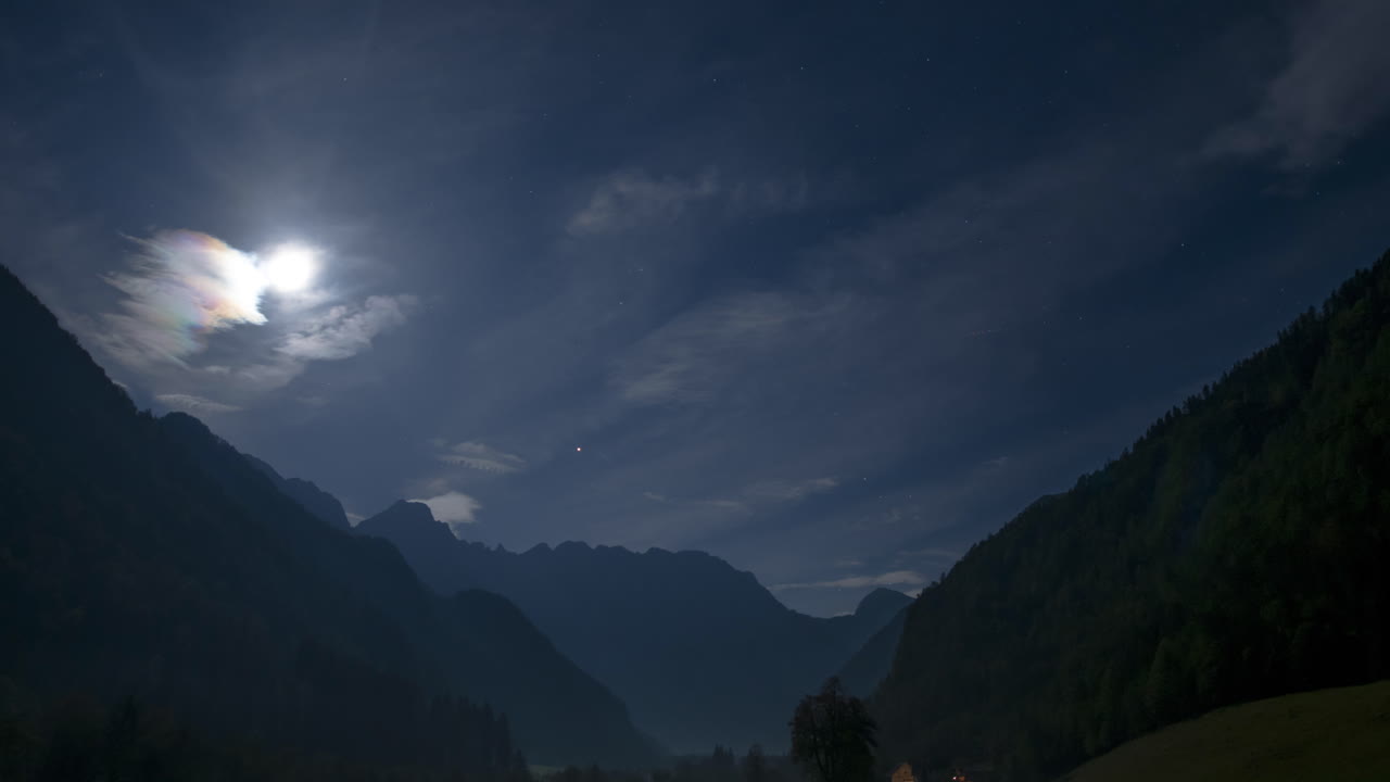 Timelapse of Alpine valley by night under full moon, illuminated ...