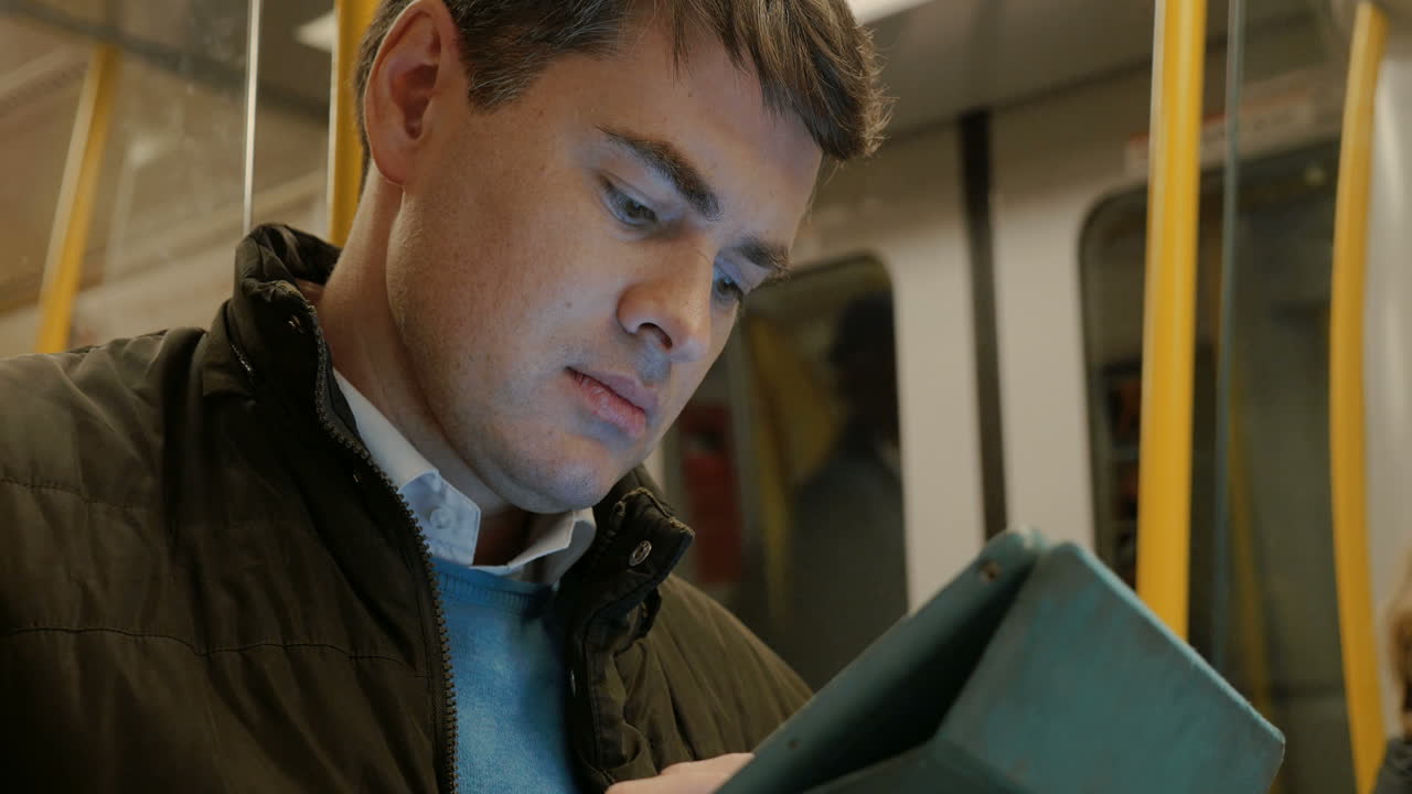 Vídeo Premium - Hombre usando una tableta en el tren del metro